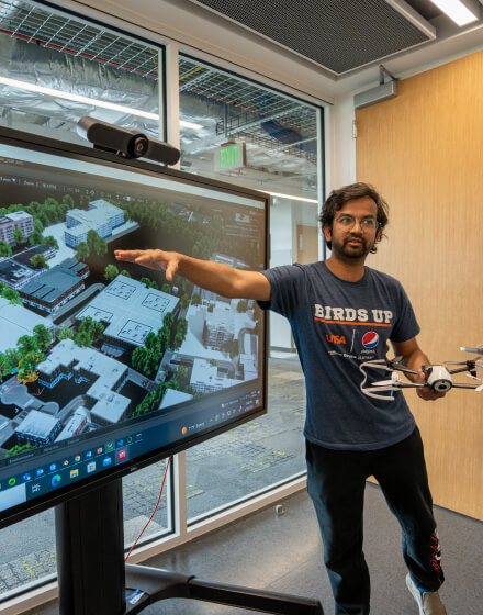 UTSA Student presenting in front of a TV