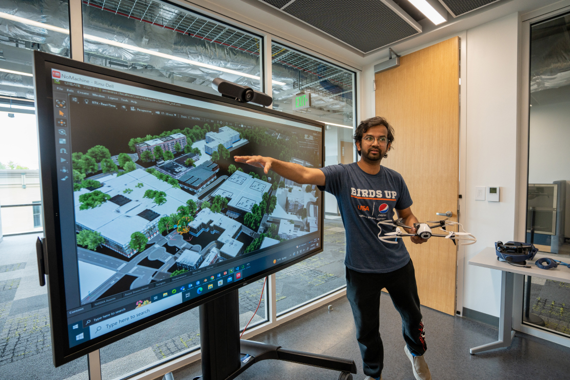 UTSA Student presenting in front of a TV